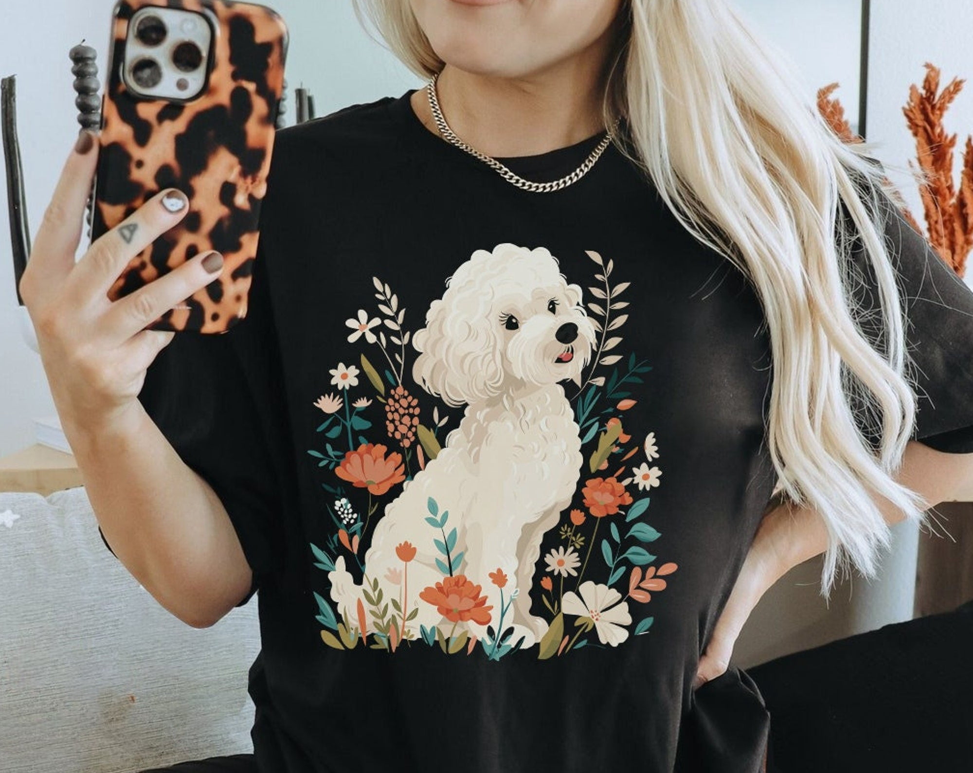 black tshirt with a white poodle sitting in a field of flowers The ...