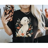 black tshirt with a white poodle sitting in a field of flowers The ...