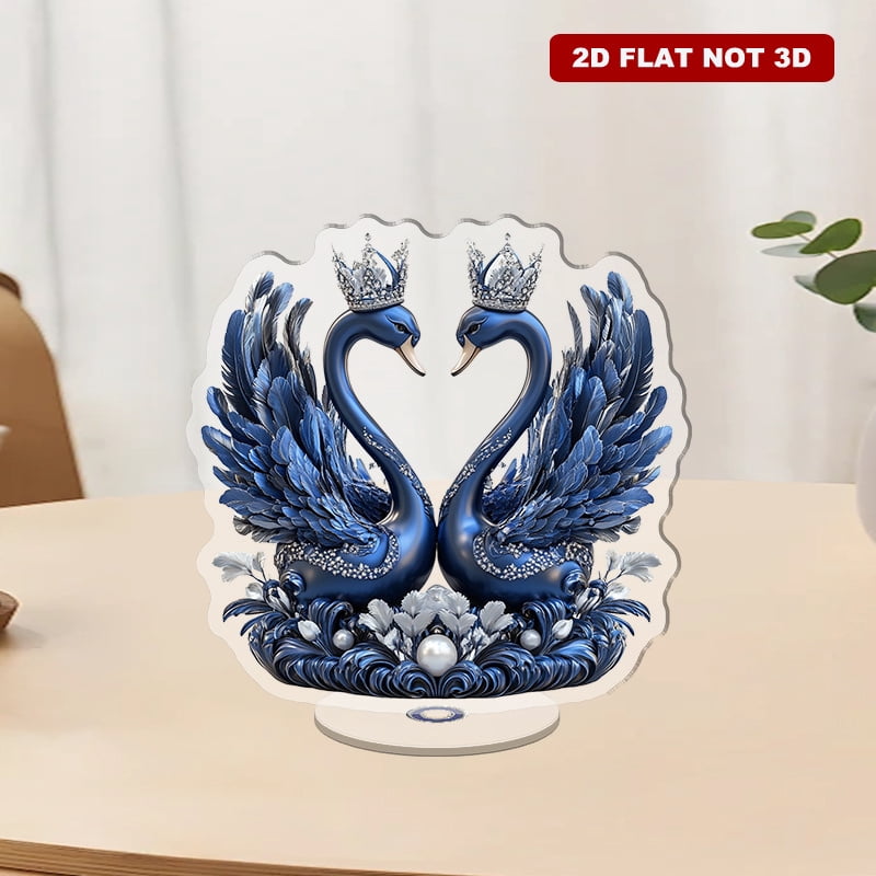 A rotating acrylic ornament featuring two blue swans adorned with pearl ...