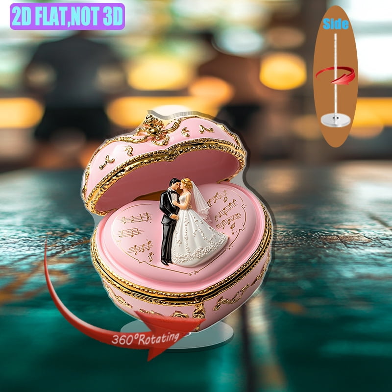 A rotating acrylic ornament showcasing a pink heart-shaped music box ...
